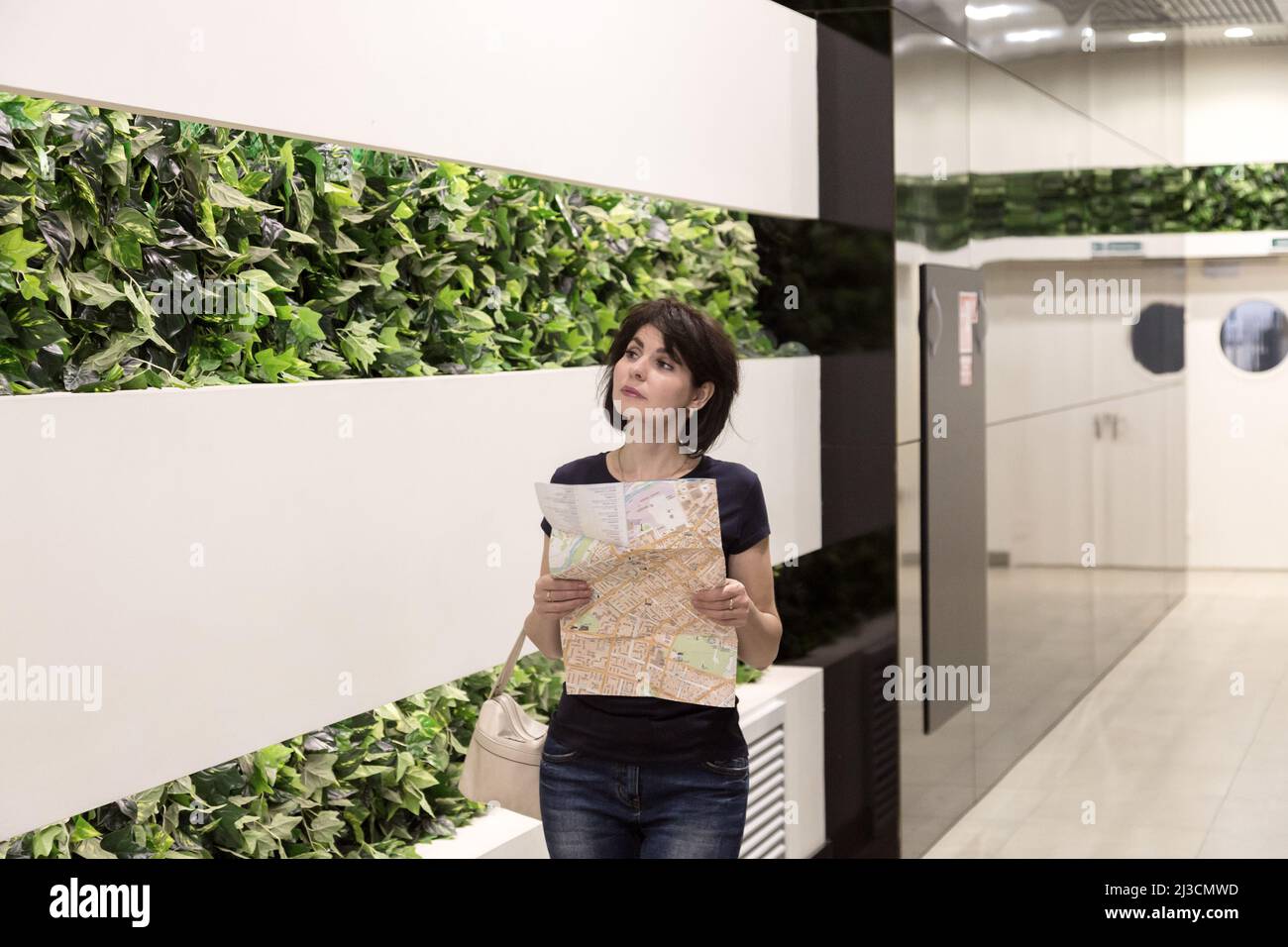 A brunette woman walks with a large card in her hands after getting ...