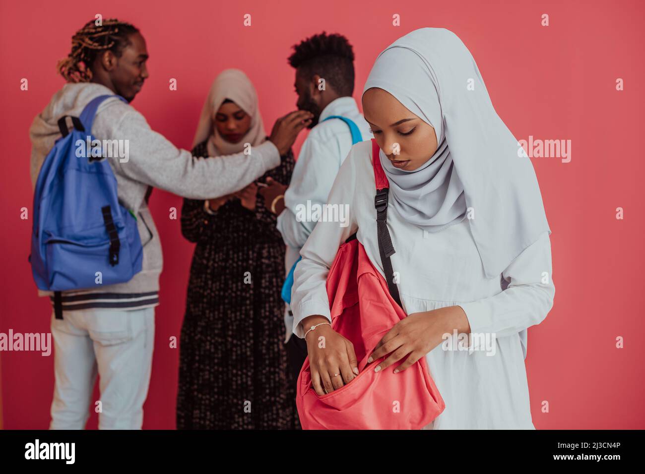 A group of African Muslim students with backpacks posing on a pink ...