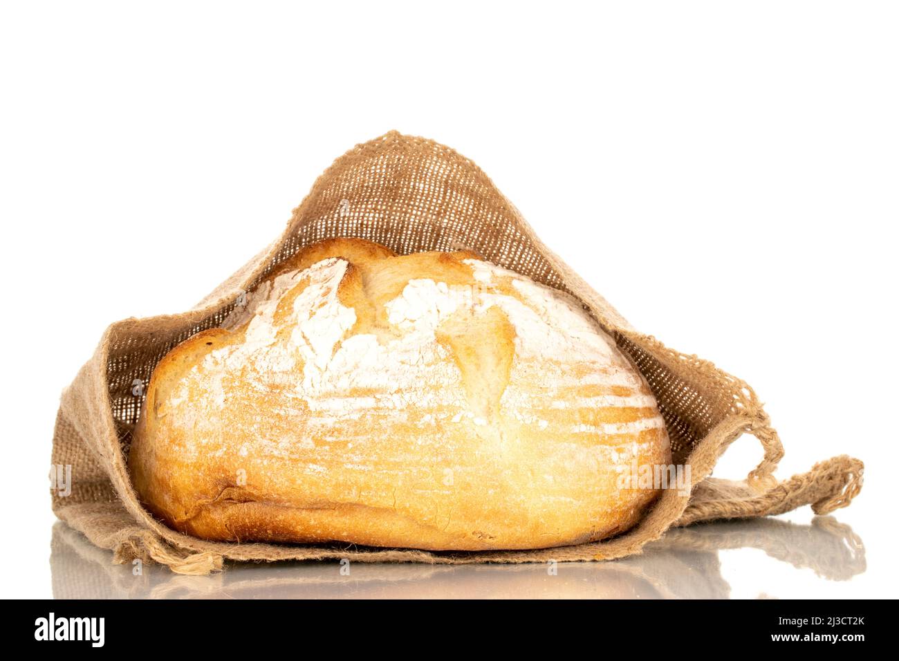 One loaf of fresh fragrant white wheat bread with a jute sack, close-up ...