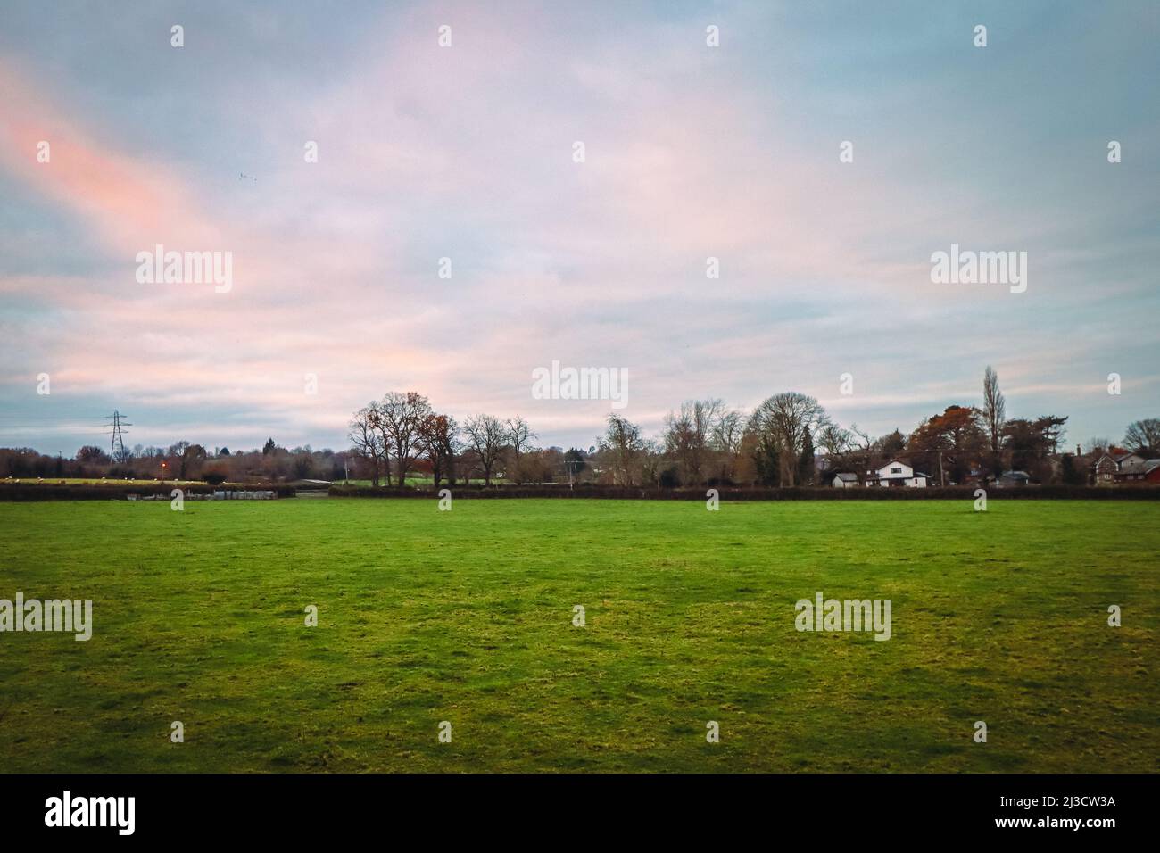 View across countryside, open field, with pink clouds and blue sky ...