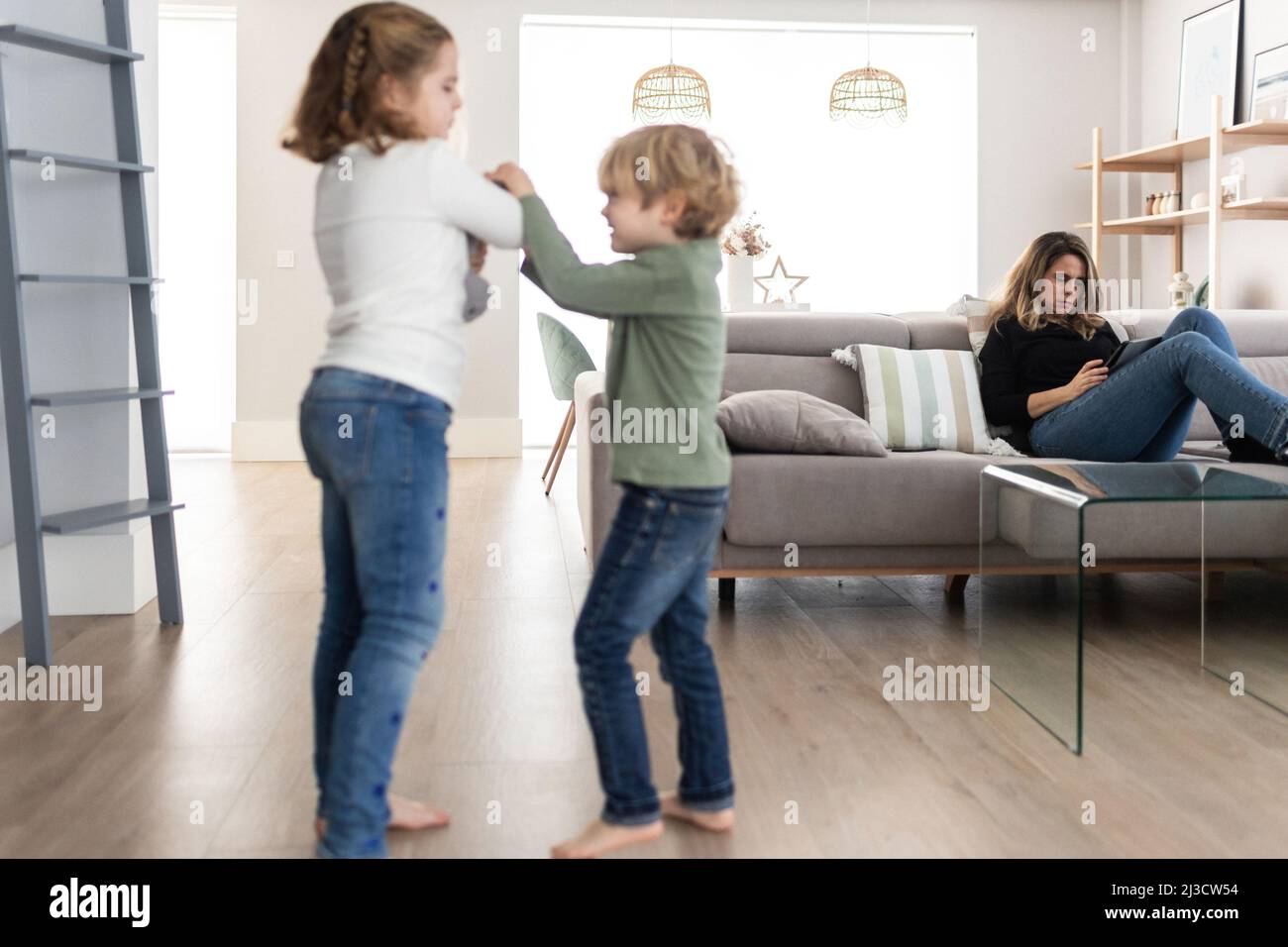 Angry sister trying to take away toy from brother while fighting in ...