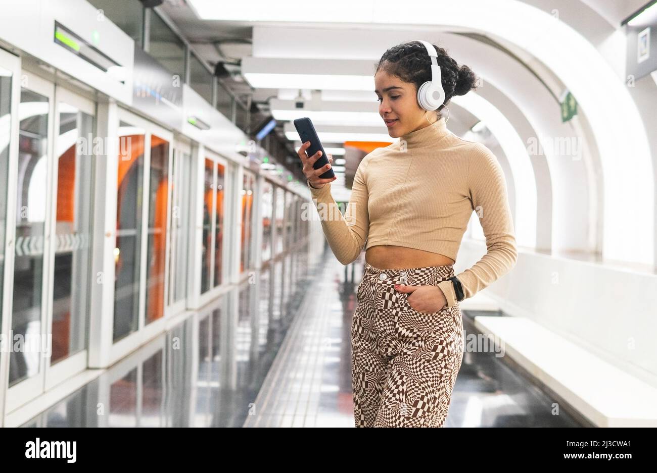 Colombian female scrolling social media on cellphone while listening to ...