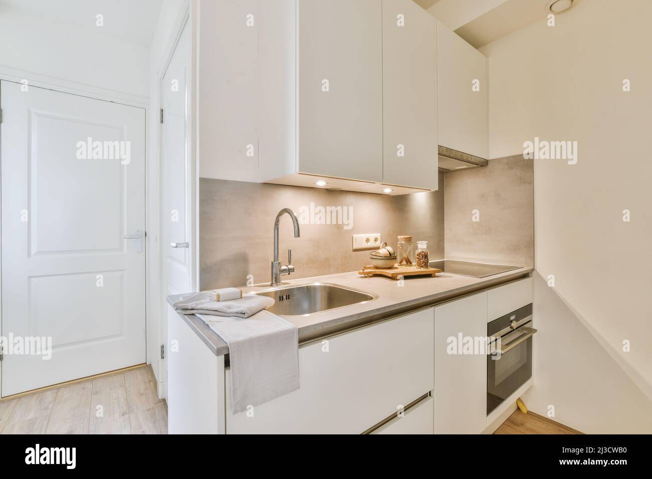 Interior of kitchen counter with sink in light stylish apartment wit ...