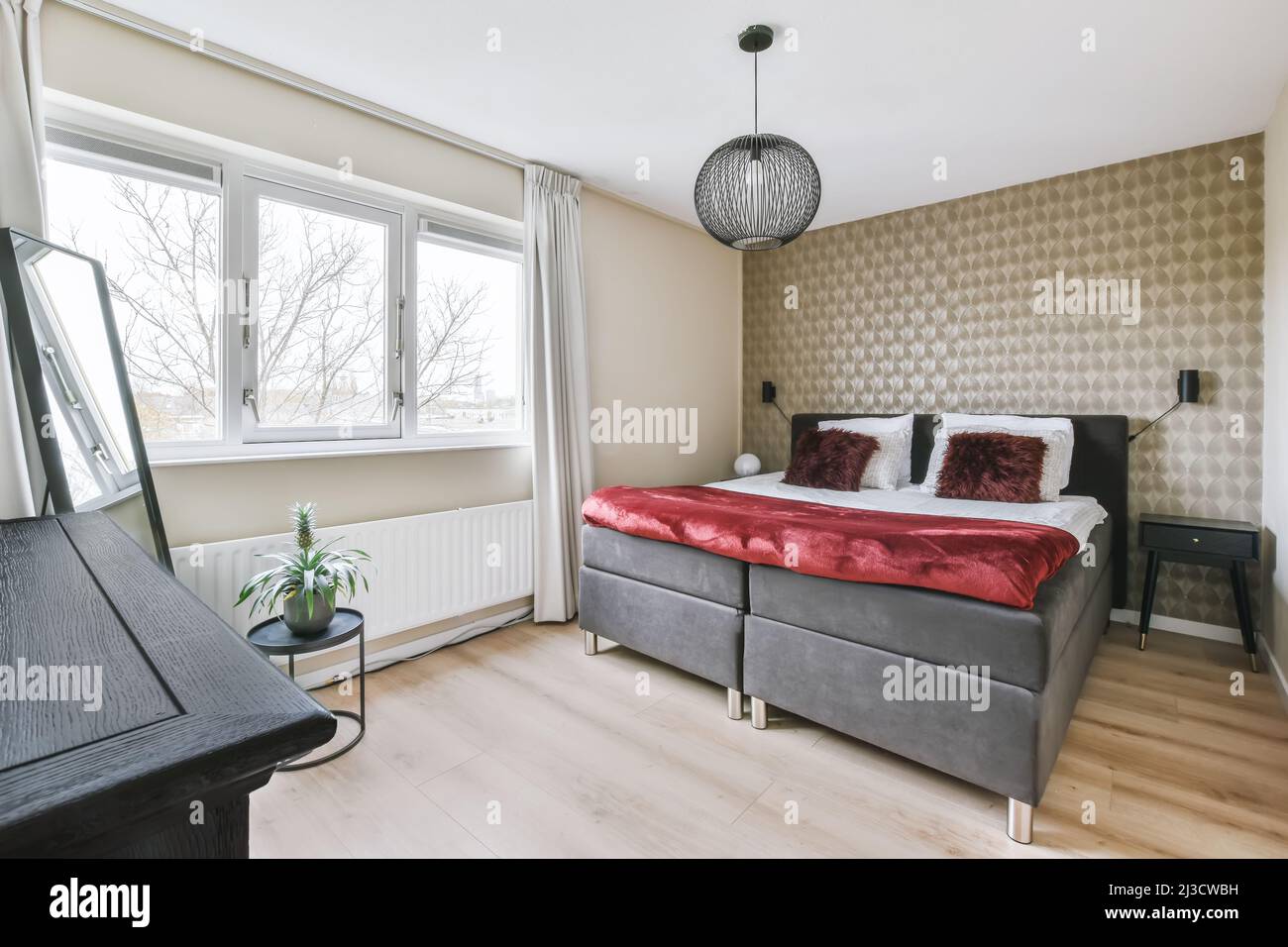 Interior of modern bedroom with soft bed placed near bedside table in ...