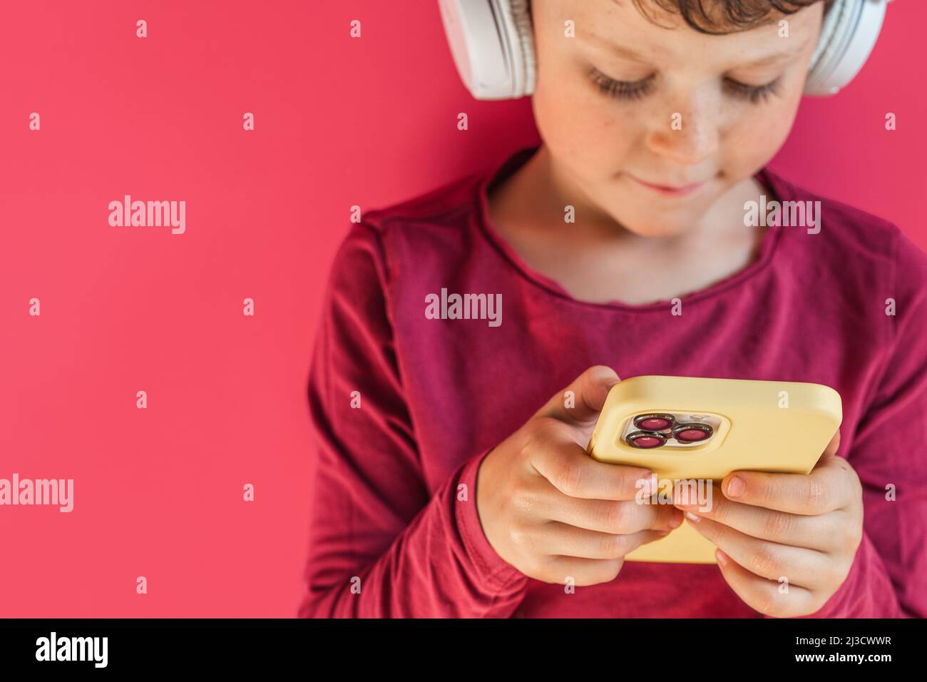 Serious boy listening to music in headphones and browsing modern ...