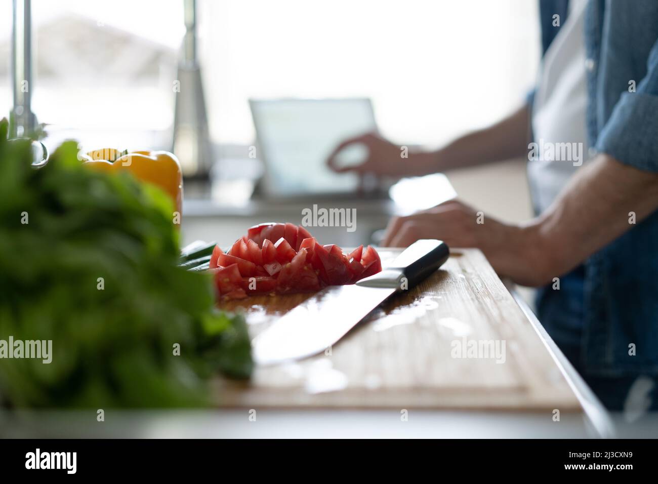 cooking, technology and home concept - man reading recipe from tablet ...