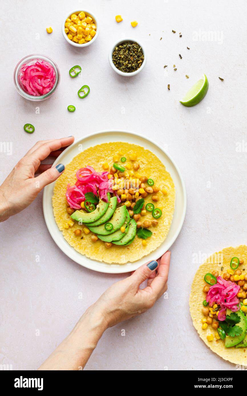 Hand of crop anonymous female touching tasty taco with ripe avocado ...