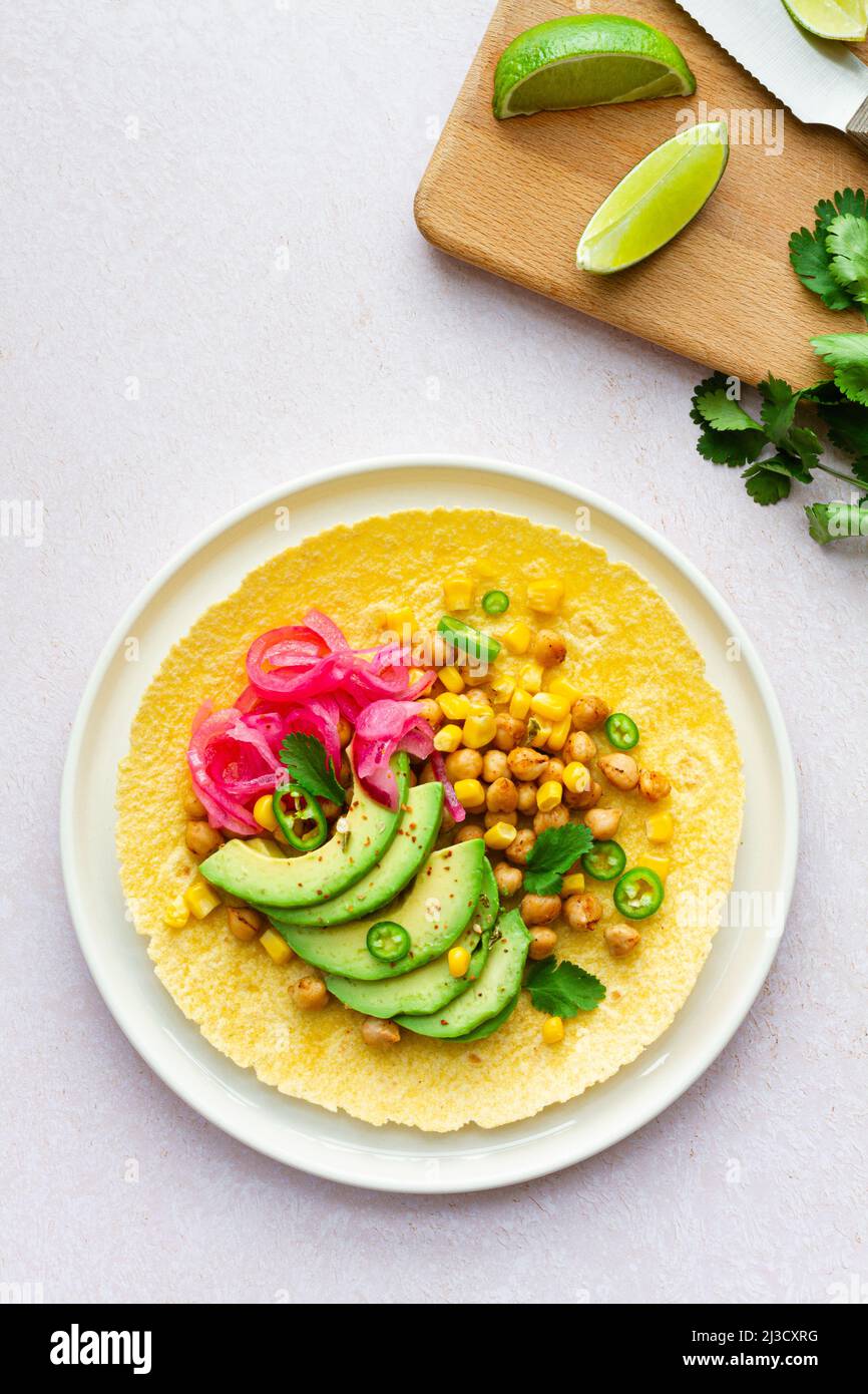 Top view of tortillas with sliced avocados and chickpeas placed on ...