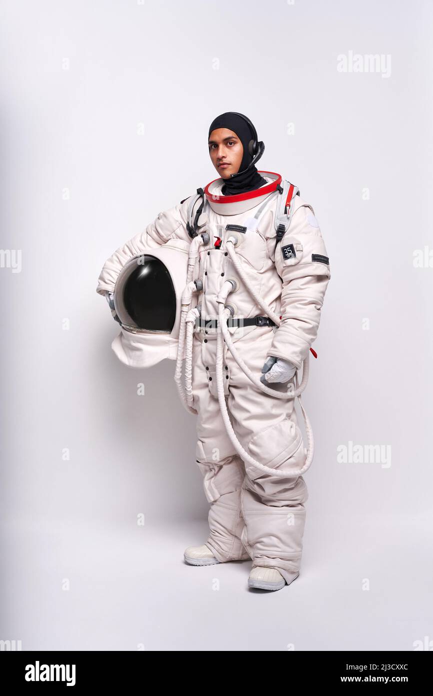 Full body of Colombian male astronaut in spacesuit with helmet in hand ...