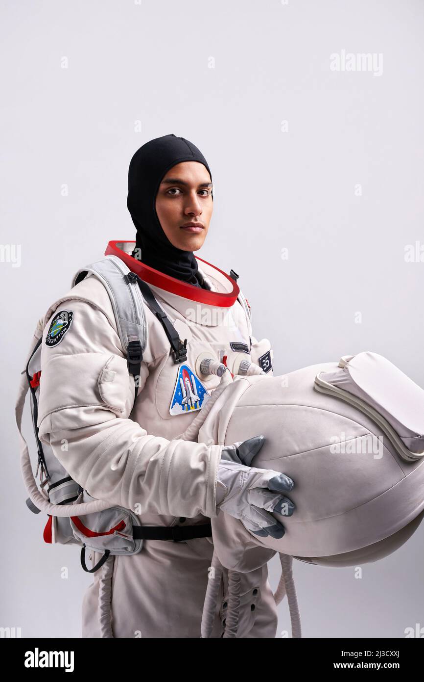 Astronaut in spacesuit taking off protective helmet with visor in ...