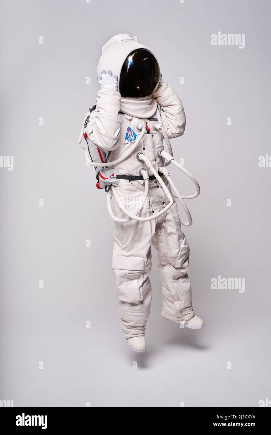 Full body side view of unrecognizable cosmonaut wearing protective ...