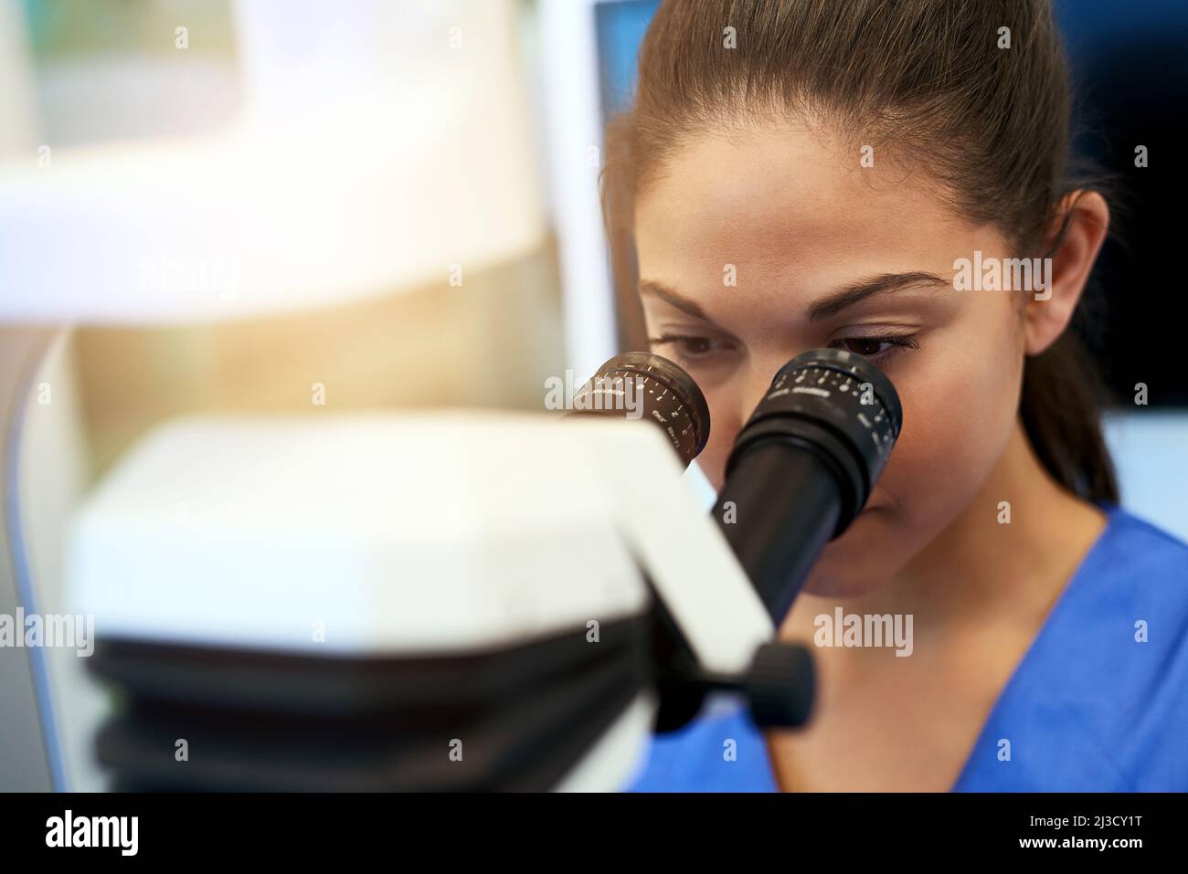 When working with microscopes, focus is key. Shot of a young ...