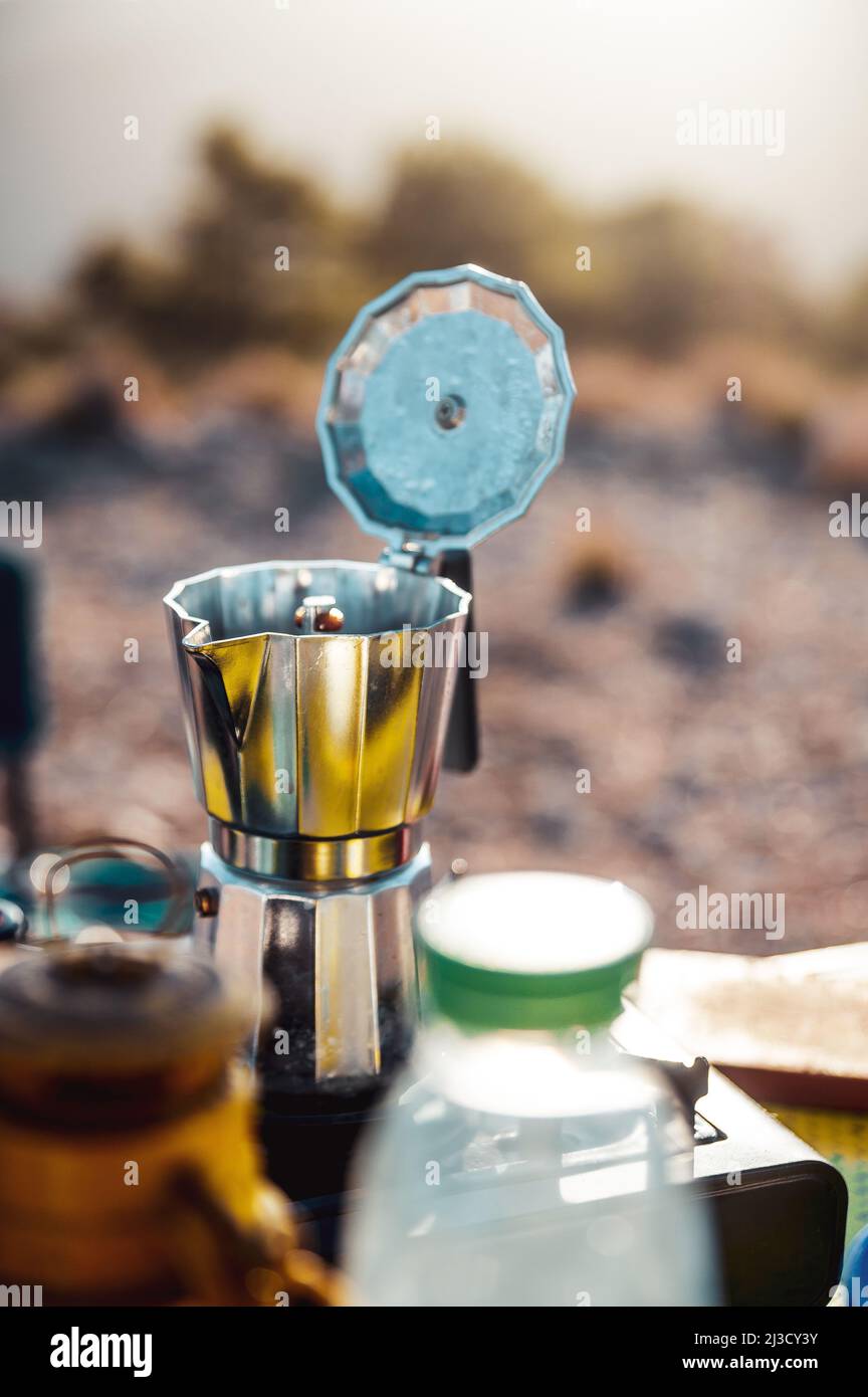 Metal make pot with opened lid placed on portable gas stove for brewing ...