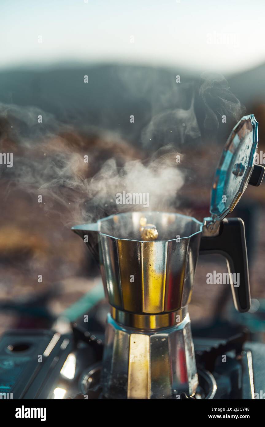 Metal make pot with opened lid placed on portable gas stove for brewing ...