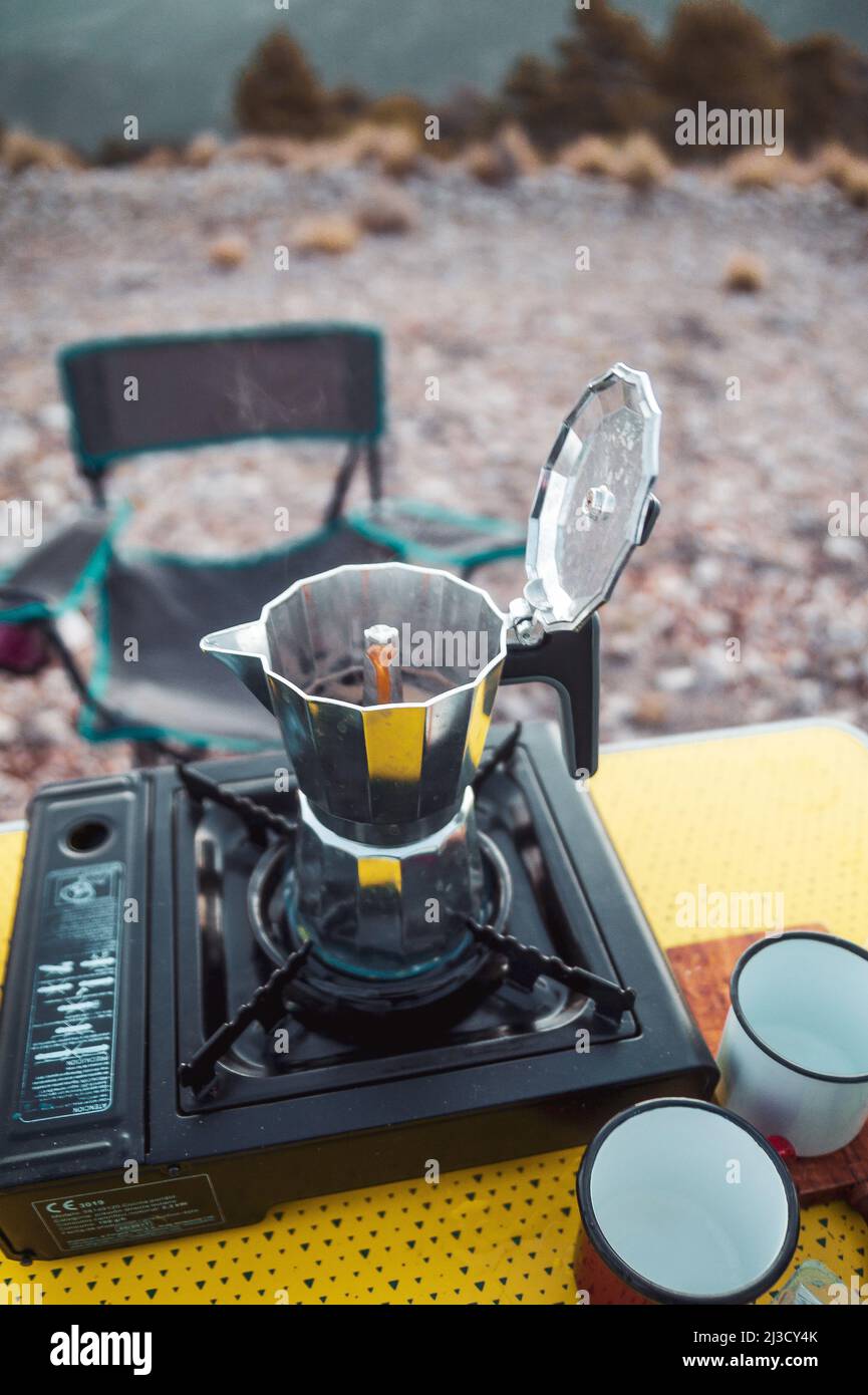 Metal make pot with opened lid placed on portable gas stove for brewing ...