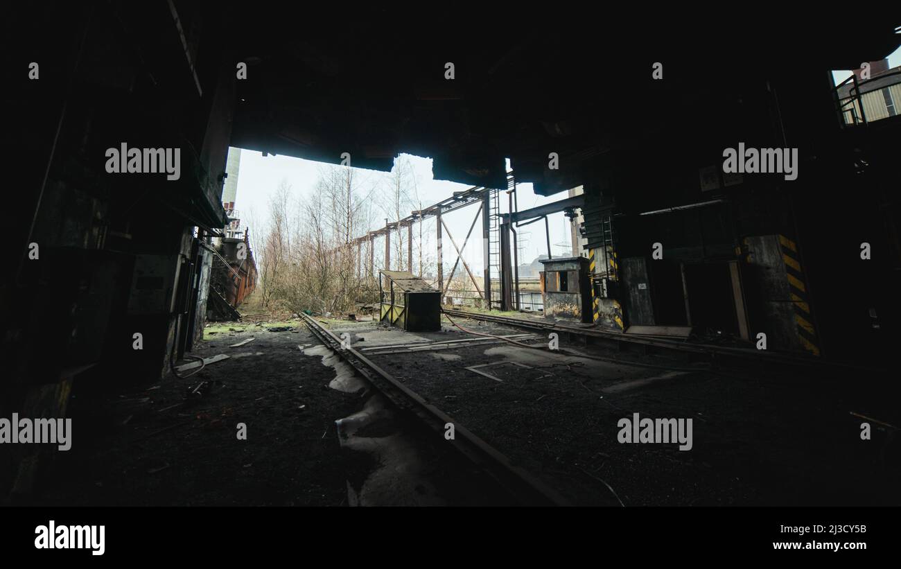Rusty rails going between storehouses and shabby main building of ...