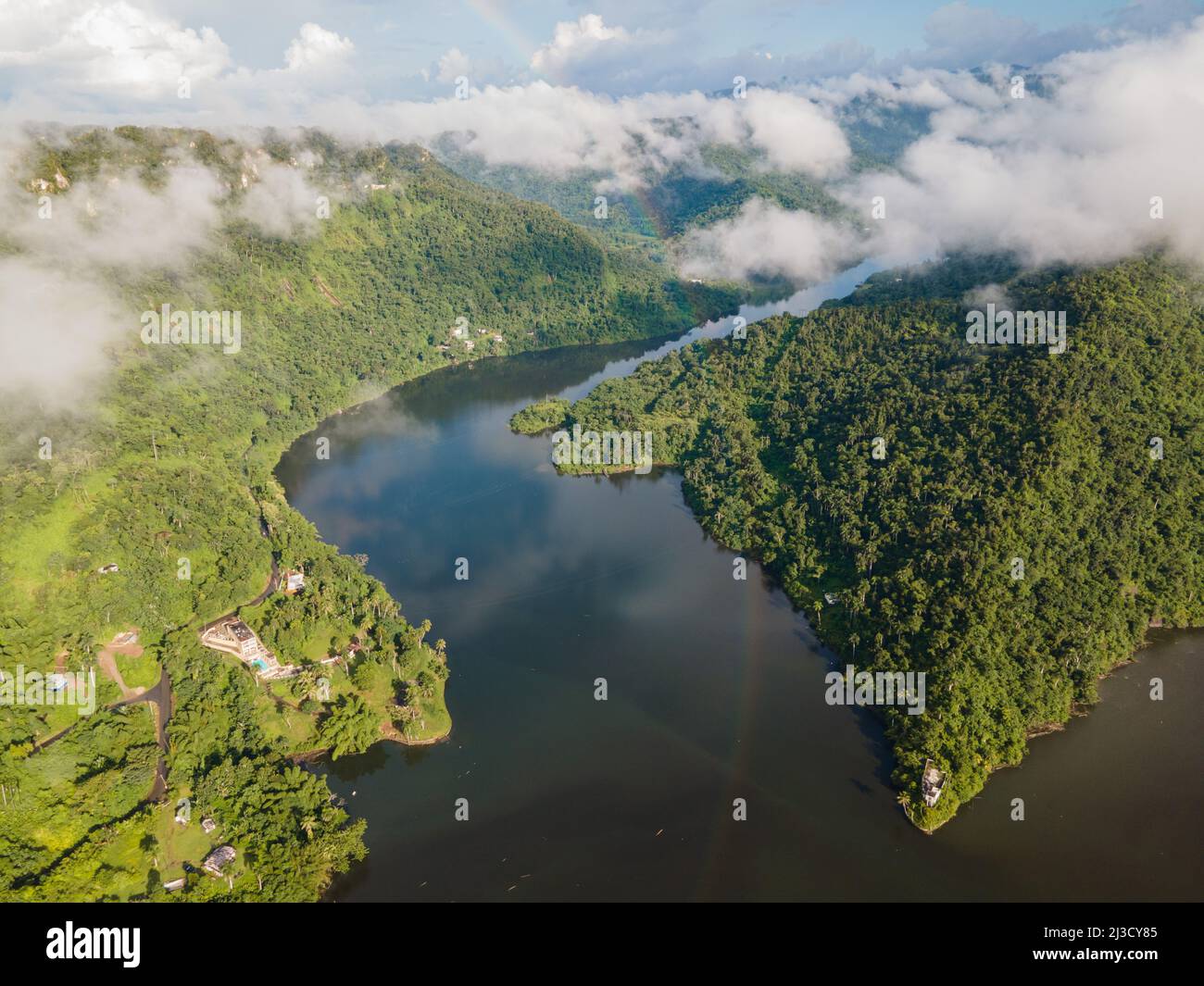 Drone view of calm winding lake streaming through hilly valley covered ...