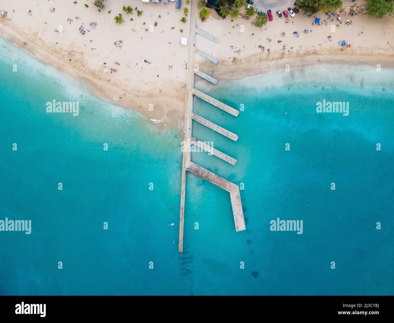 Aerial view of quay with breakwaters on sandy coast washed by turquoise ...