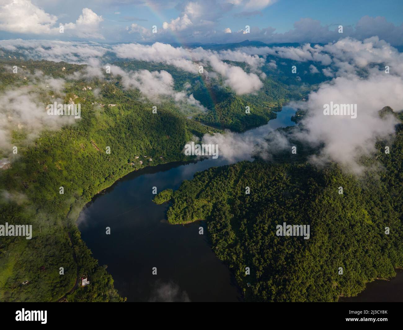 Drone view of calm winding lake streaming through hilly valley covered ...