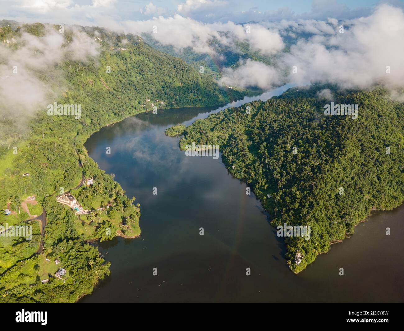 Drone view of calm winding lake streaming through hilly valley covered ...