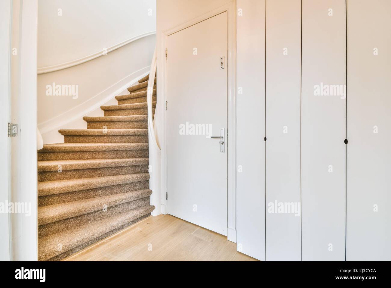 Long staircase with railings placed in light spacious corridor with ...