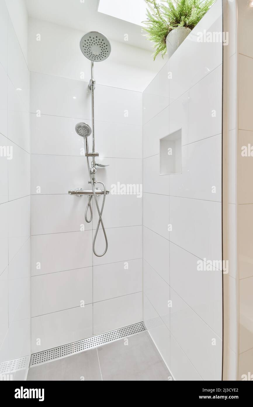 White shower in light spacious bathroom and tiled walls Stock Photo - Alamy