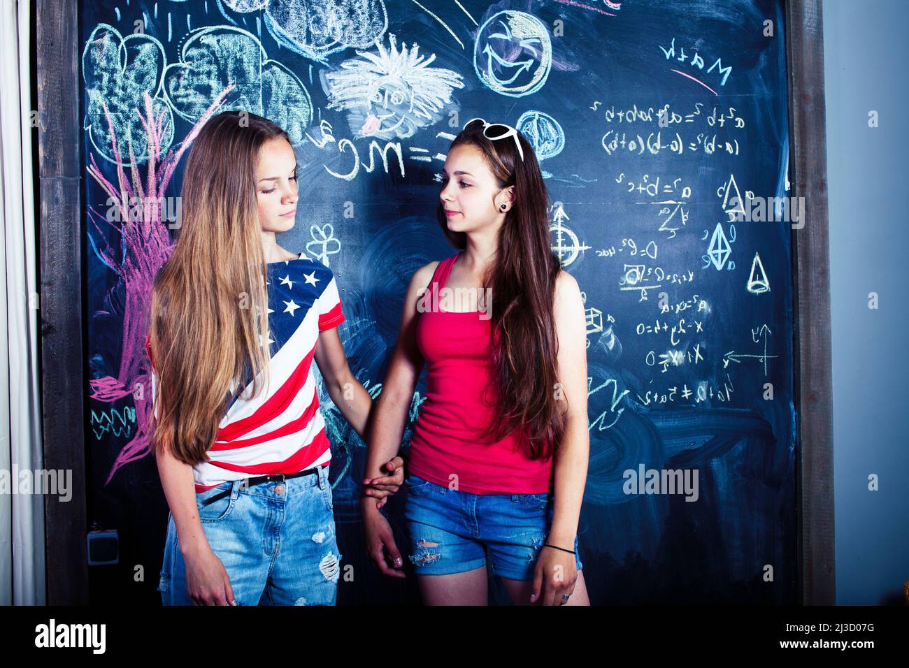 back to school after summer vacations, two teen girls in classroom with ...