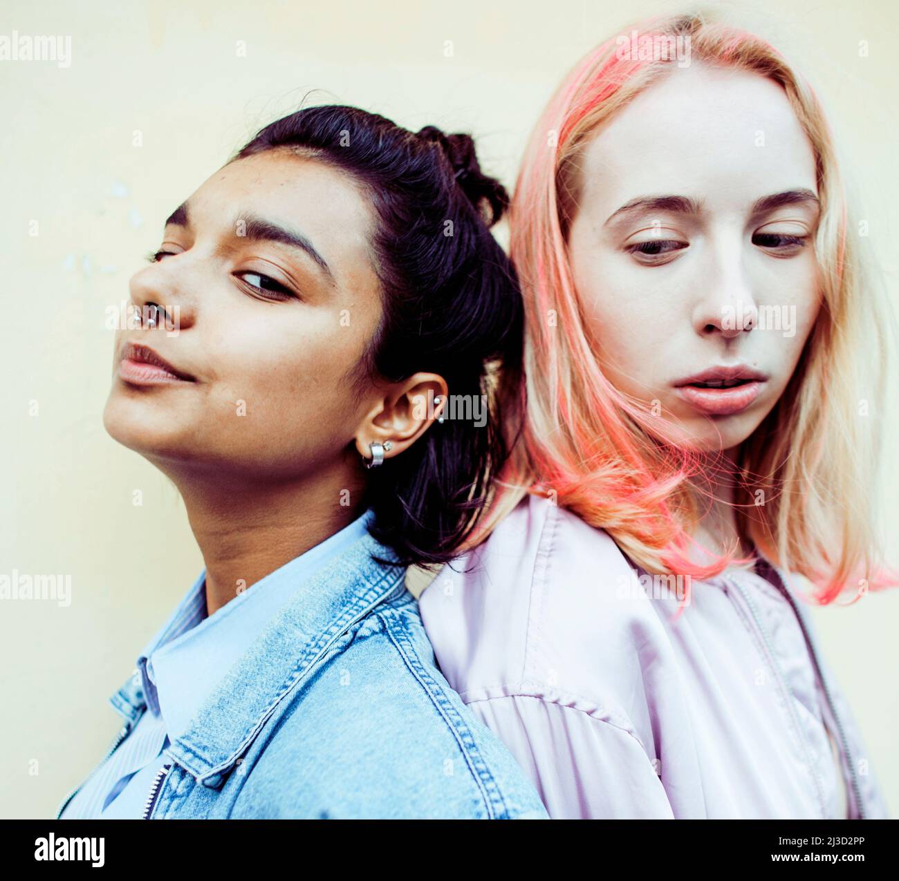 Two teenage girls infront of university building smiling, having fun ...