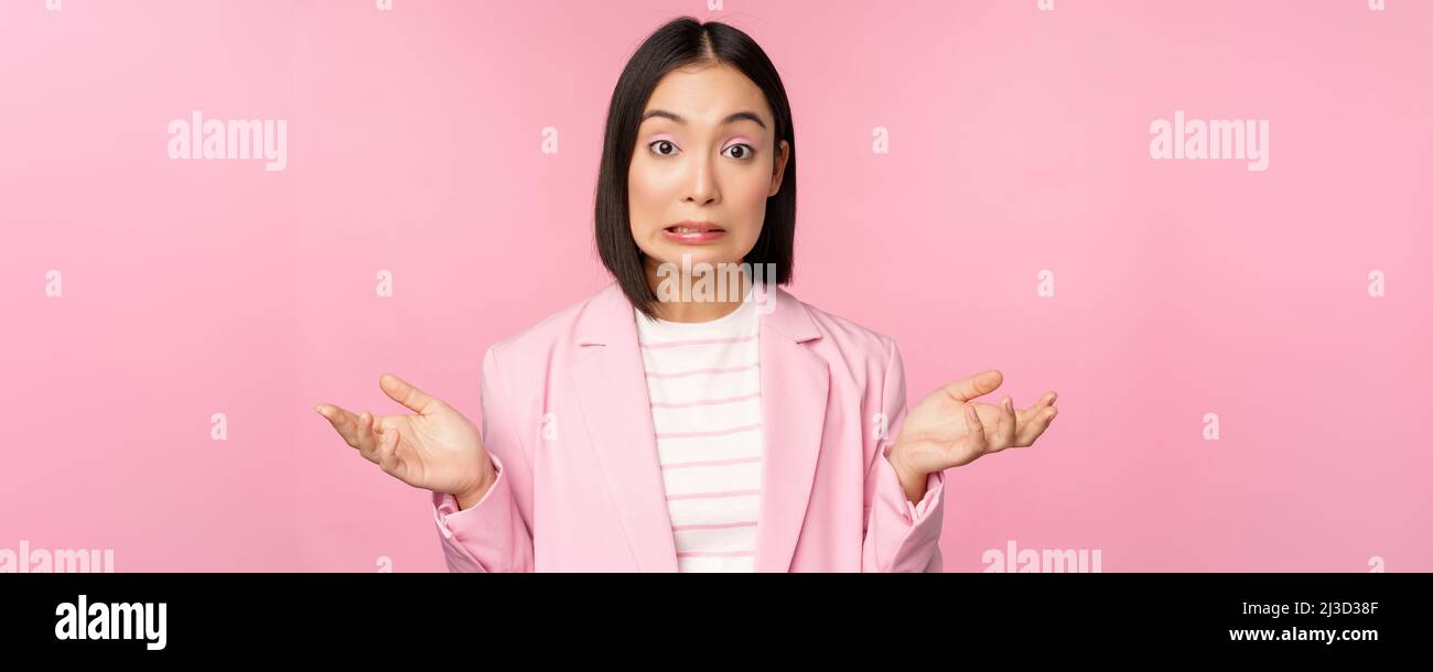 Portrait of confused asian businesswoman shrugging shoulders, looking ...