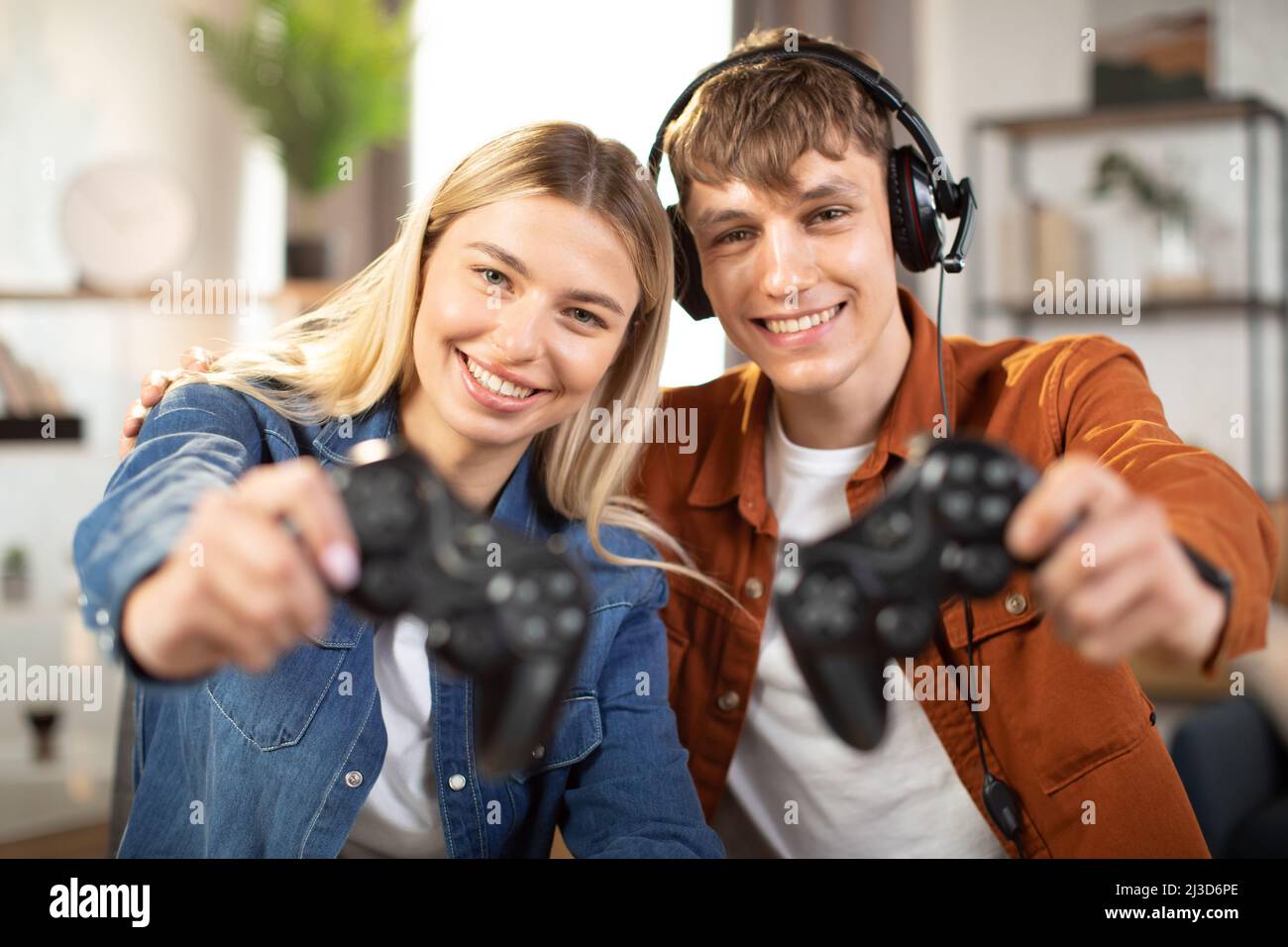 Waist up portrait of happy young people, handsome man and pretty blond ...