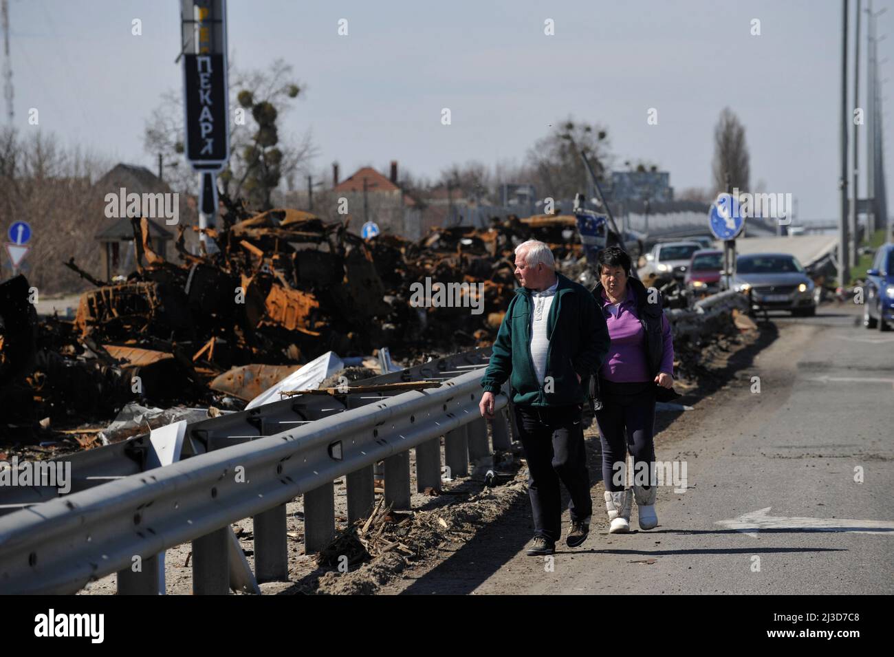 A man and woman walk past destroyed military equipment of the Russian ...