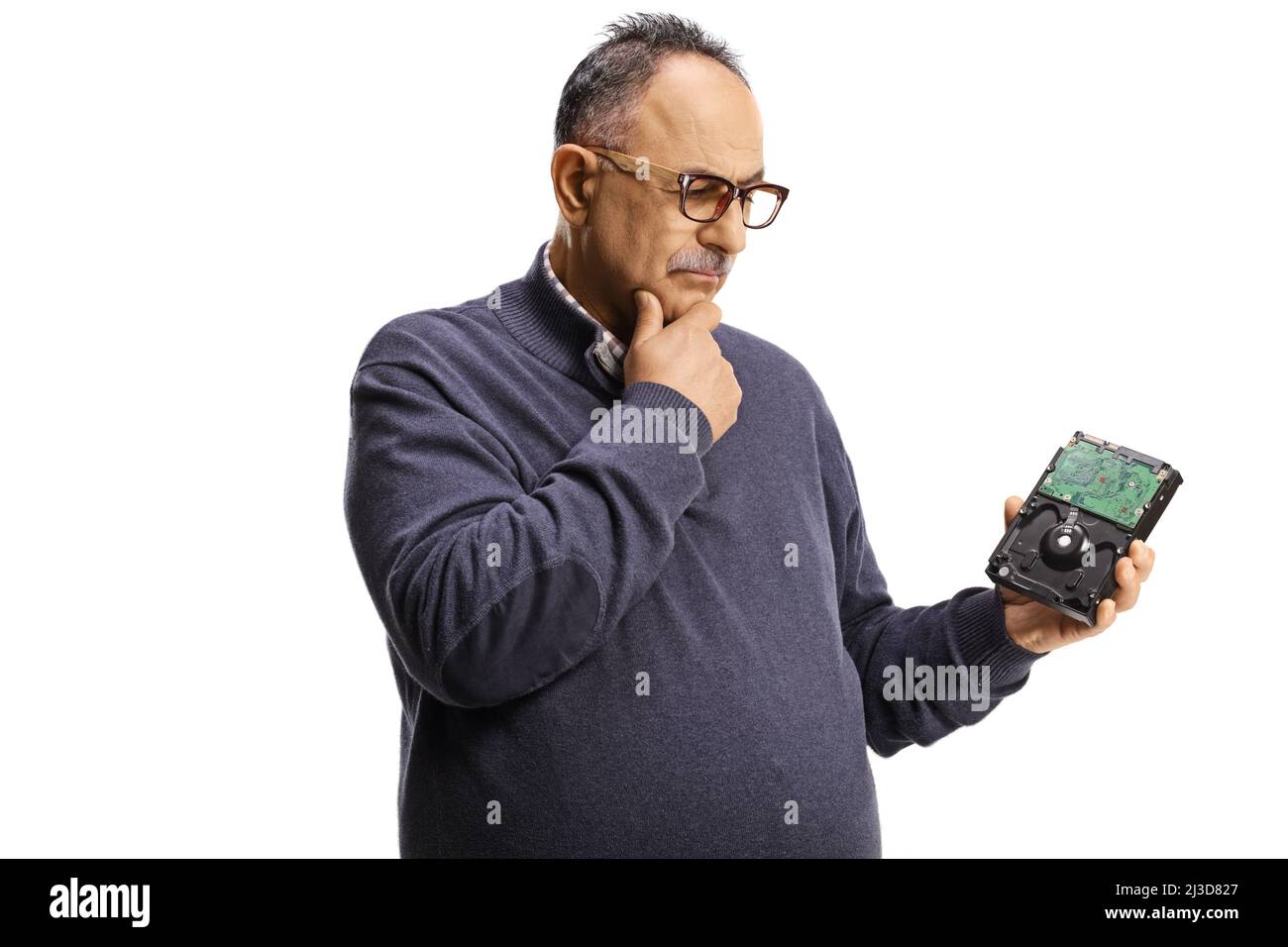 Mature man holding a computer hard drive and thinking isolated on white ...