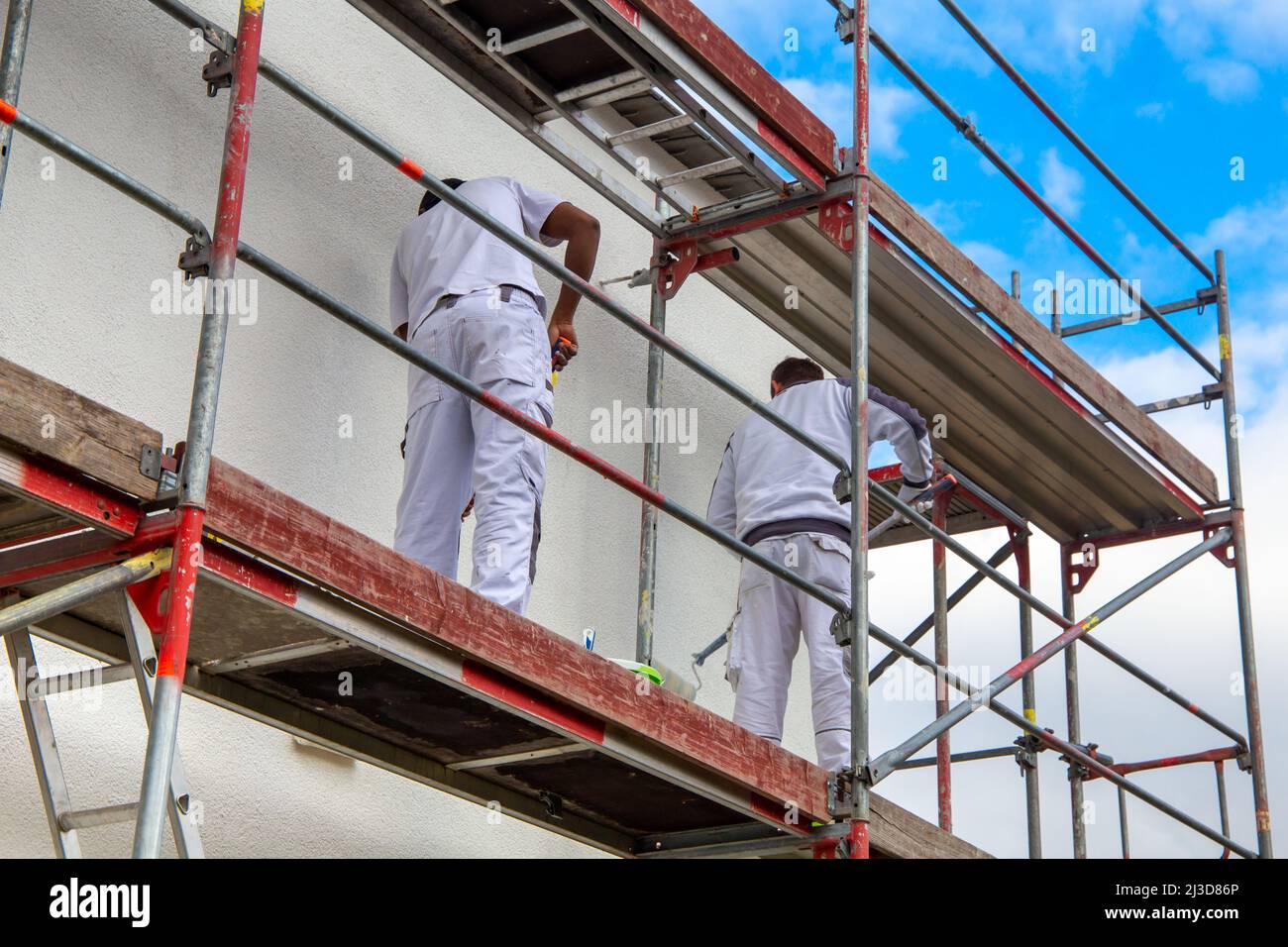 Painter painting the facade of a new residential building Stock Photo ...