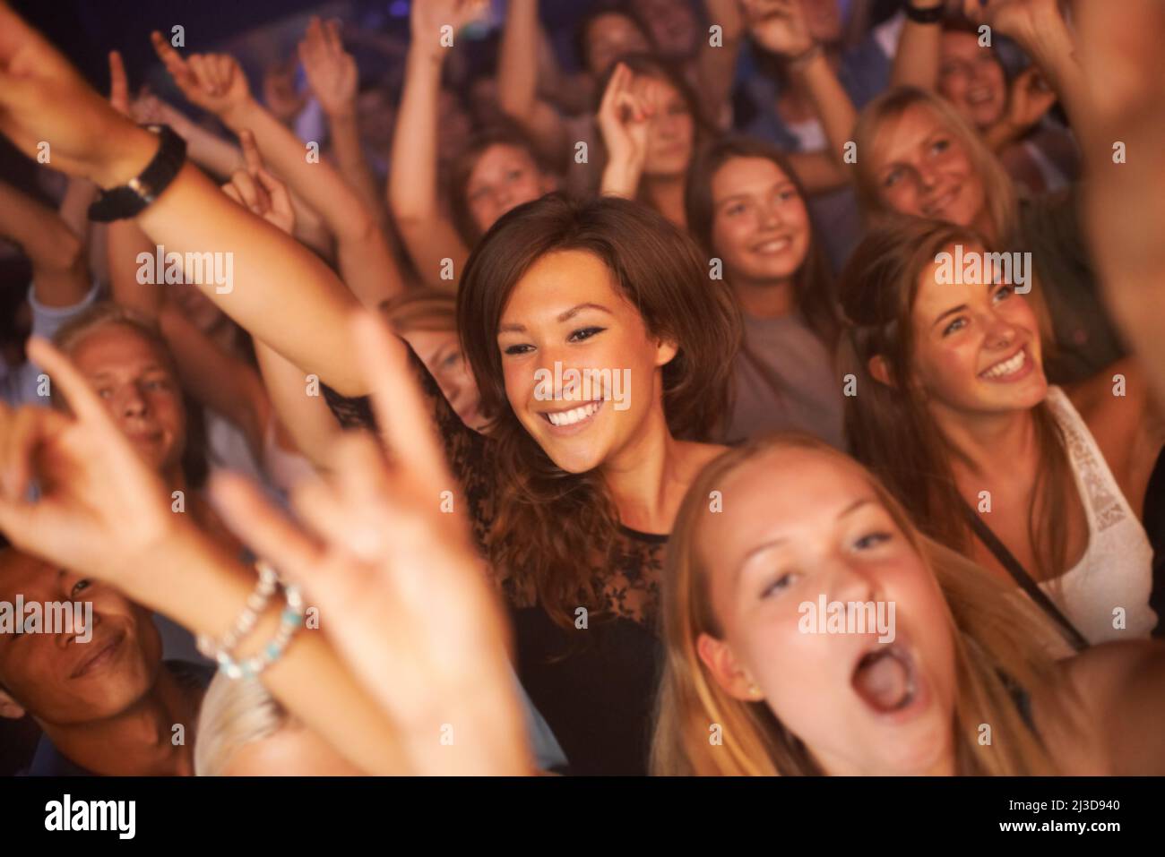 Singing every word to the song. Attractive female fans enjoying a ...
