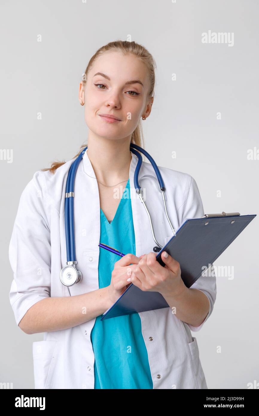 Young woman doctor filling patient form. Portrait on white Stock Photo ...