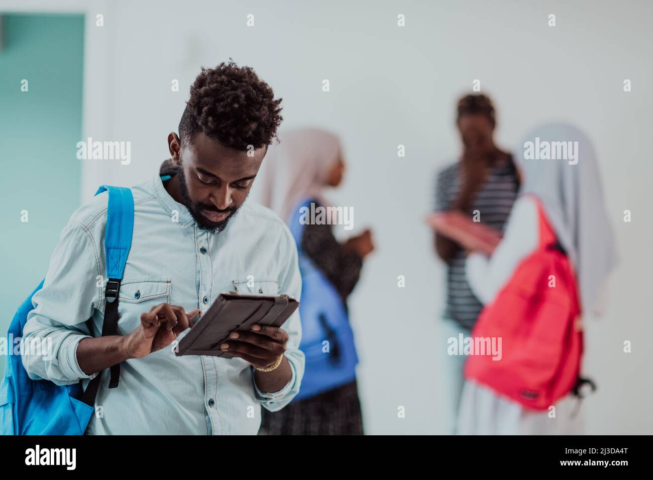 University lifestyle handsome young African student man holding a ...