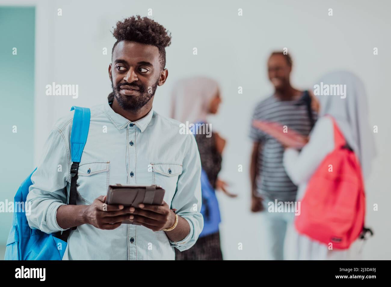 University lifestyle handsome young African student man holding a ...