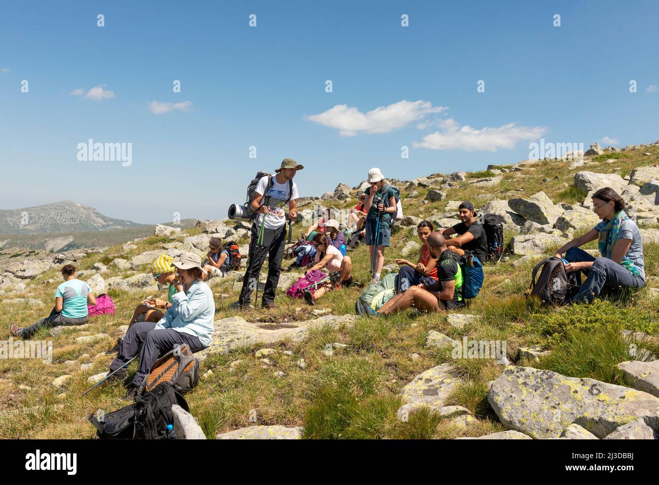 Hikers resting on hiking trail in Rila National Park and Nature Reserve ...