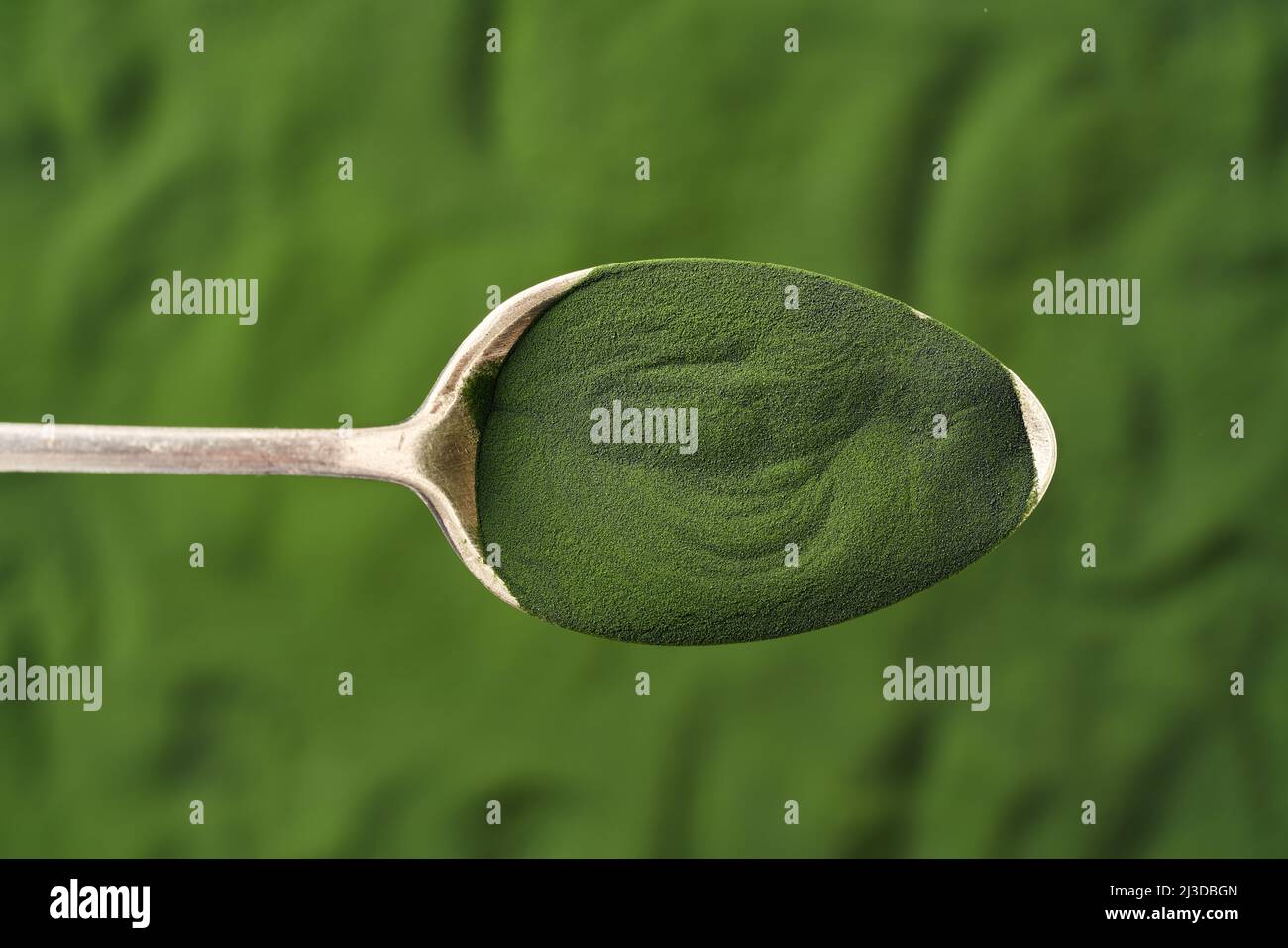 Green chlorella algae powder on a metal spoon - healthy nutritional ...