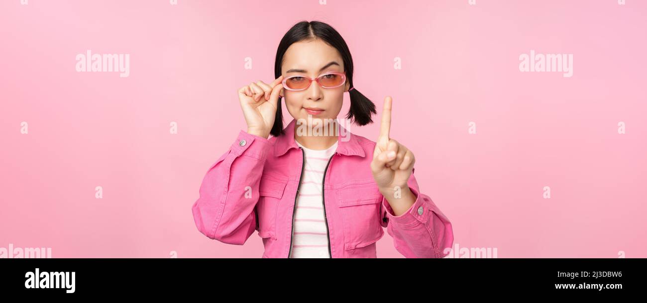 Image of asian girl with serious face, showing prohibit, scolding ...