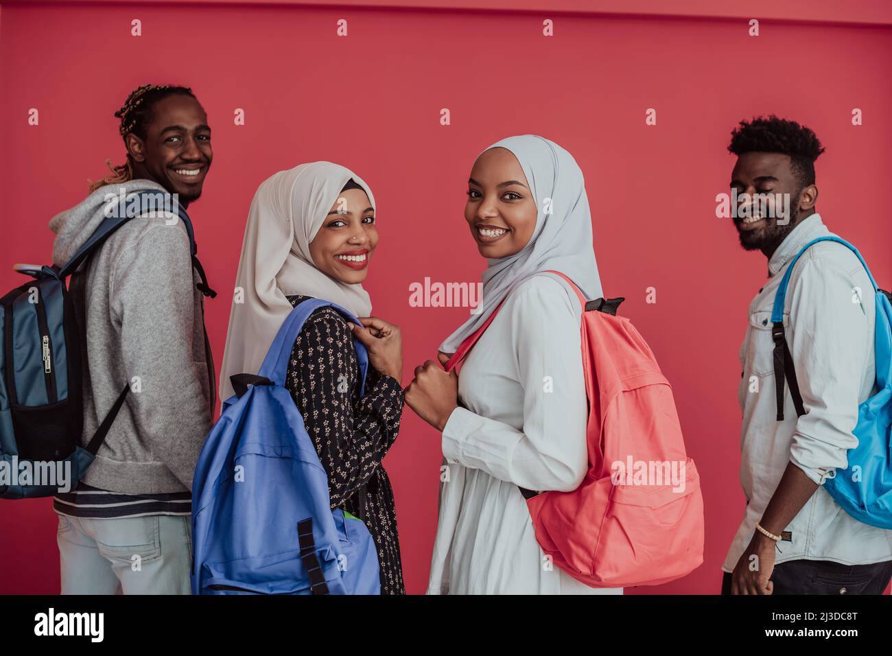 A group of African Muslim students with backpacks posing on a pink ...