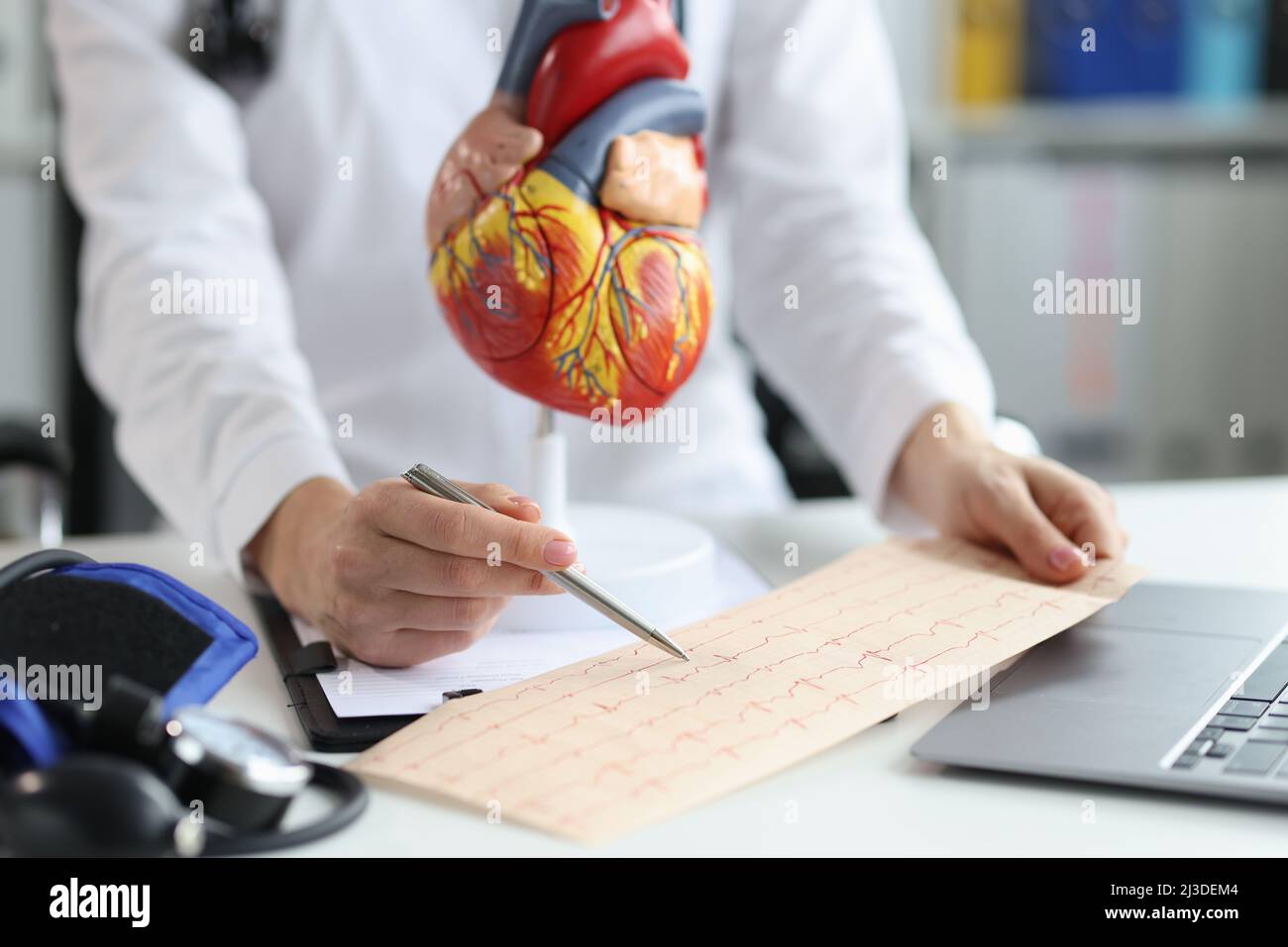 Doctor cardiologist examines electrocardiogram of patient heart in ...