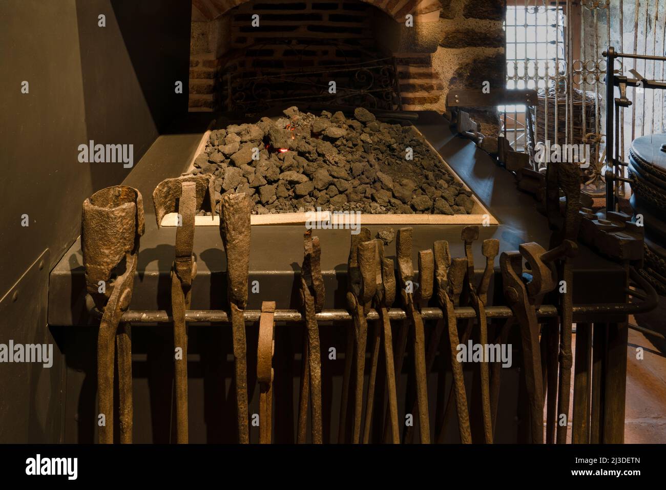 Traditional blacksmith shop with coal and metal tools Stock Photo - Alamy