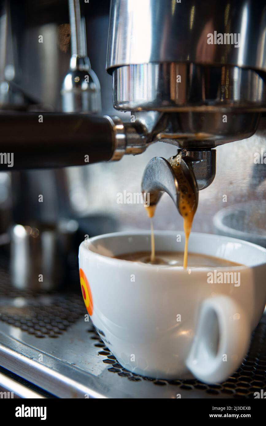Creamy coffee pouring from a coffee machine up close Stock Photo - Alamy