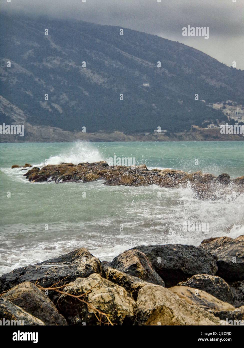 Natural environmental view of waves crashing over dark rocks Stock ...