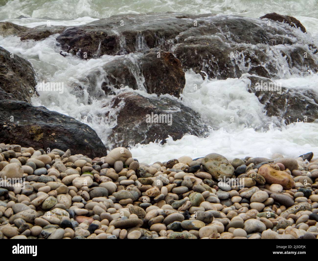 Natural environmental view of waves crashing over dark rocks Stock ...