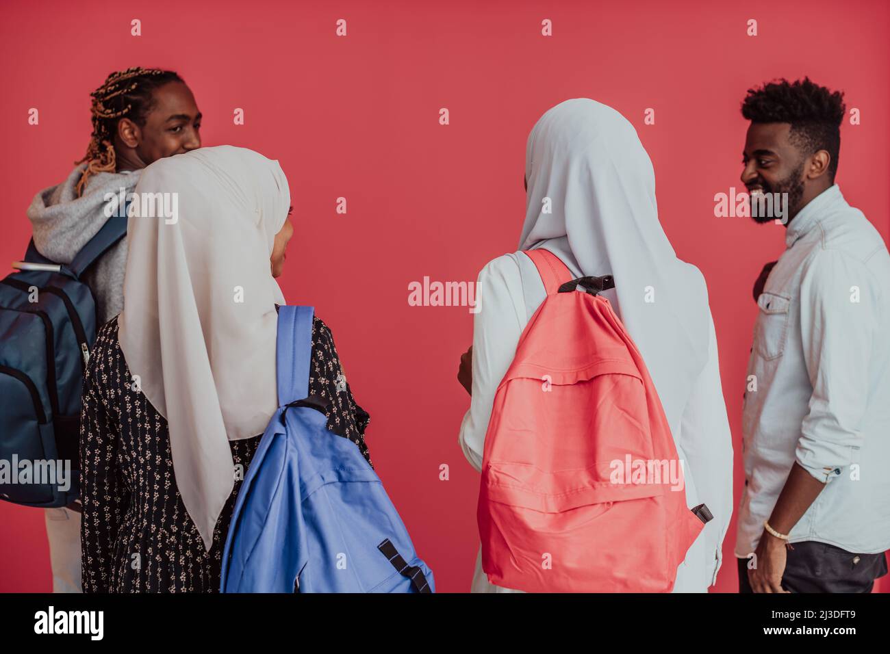 A group of African Muslim students with backpacks posing on a pink ...