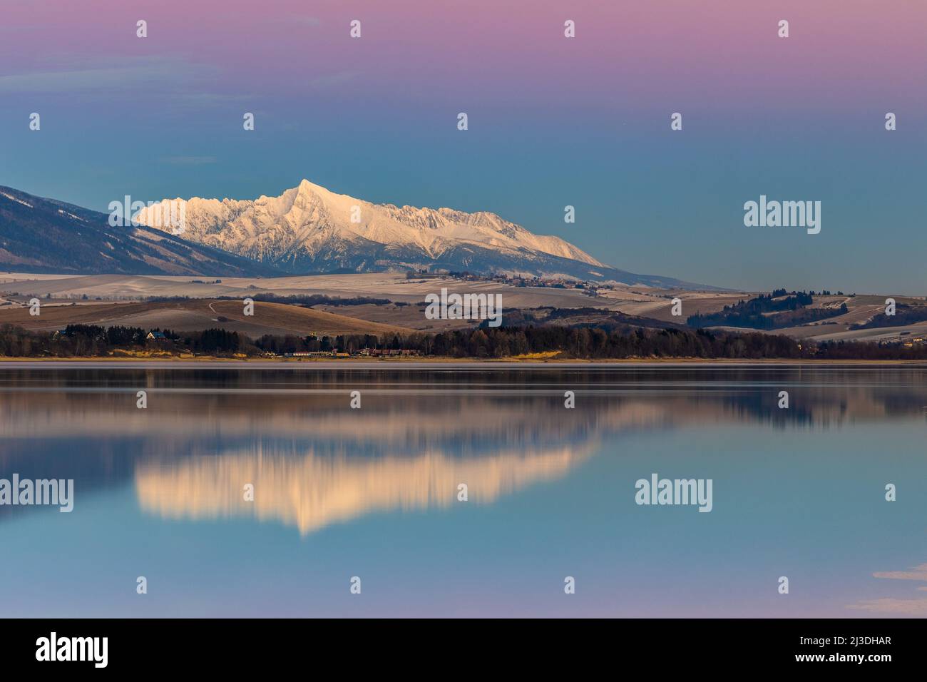 Winter landscape at sunset. Snow-capped The Krivan peak reflected in ...