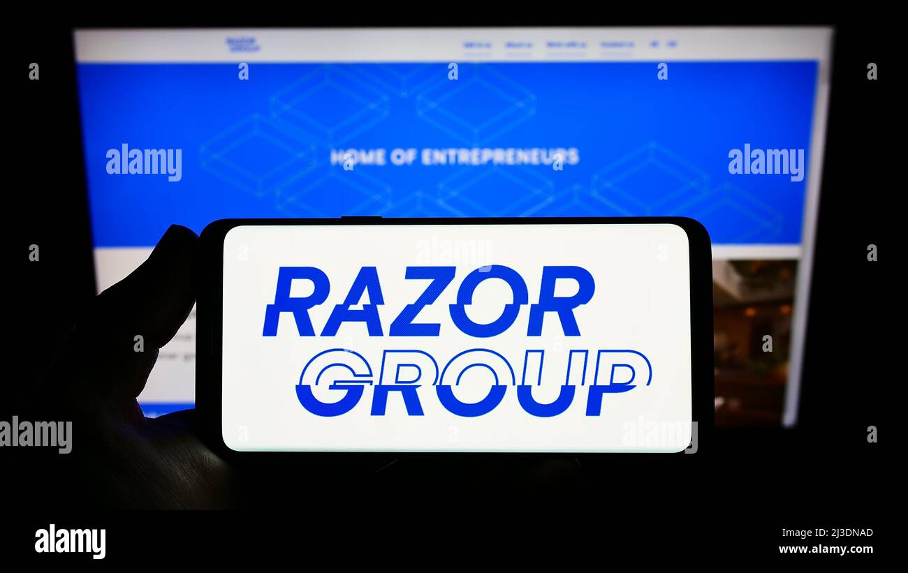 Person holding smartphone with logo of German e-commerce company Razor ...