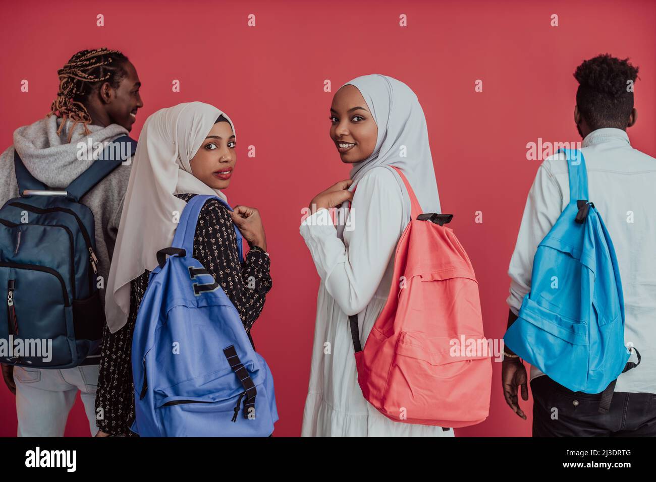 A group of African Muslim students with backpacks posing on a pink ...